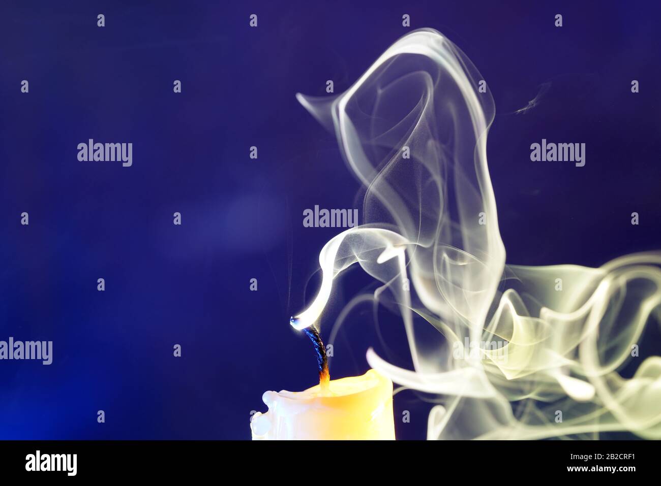 Candle with smoke and flame photographed in the studio with color foils ...