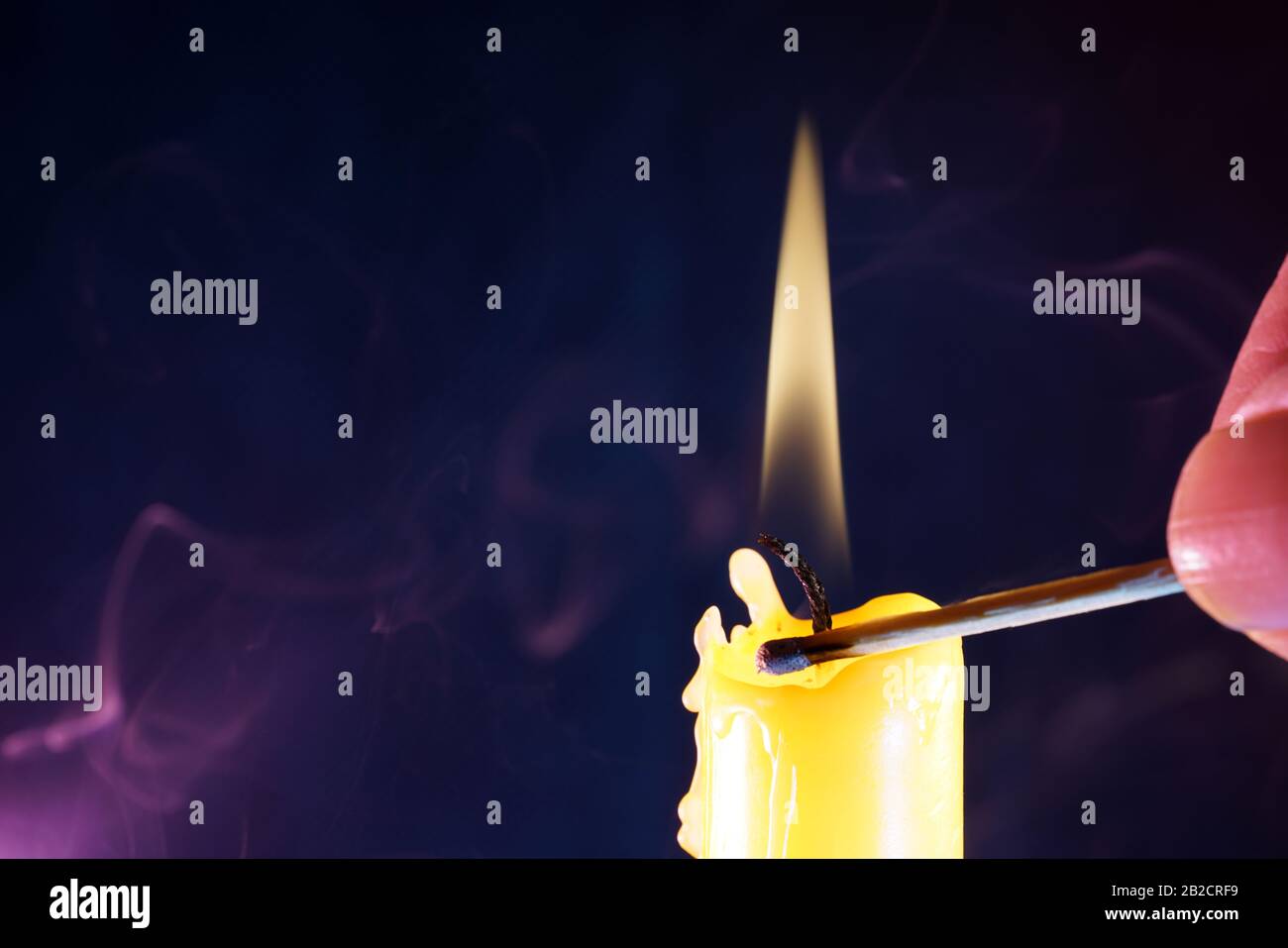 Candle with smoke and flame photographed in the studio with color foils ...