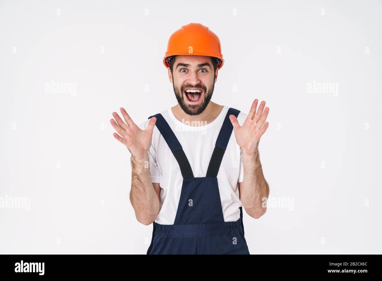 Photo of a shocked surprised young man builder in helmet posing ...