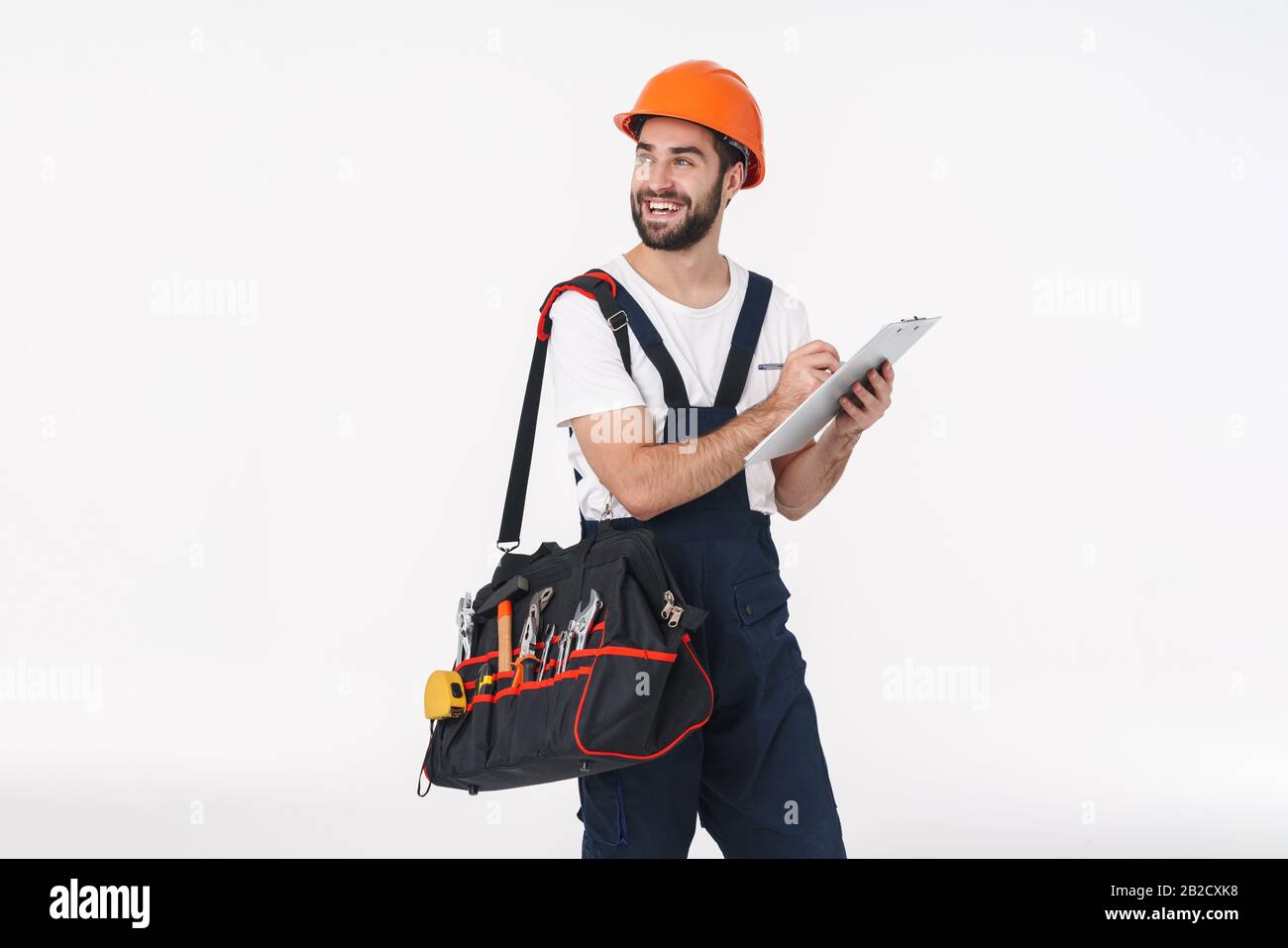 Image of smiling positive young man builder in helmet isolated over ...