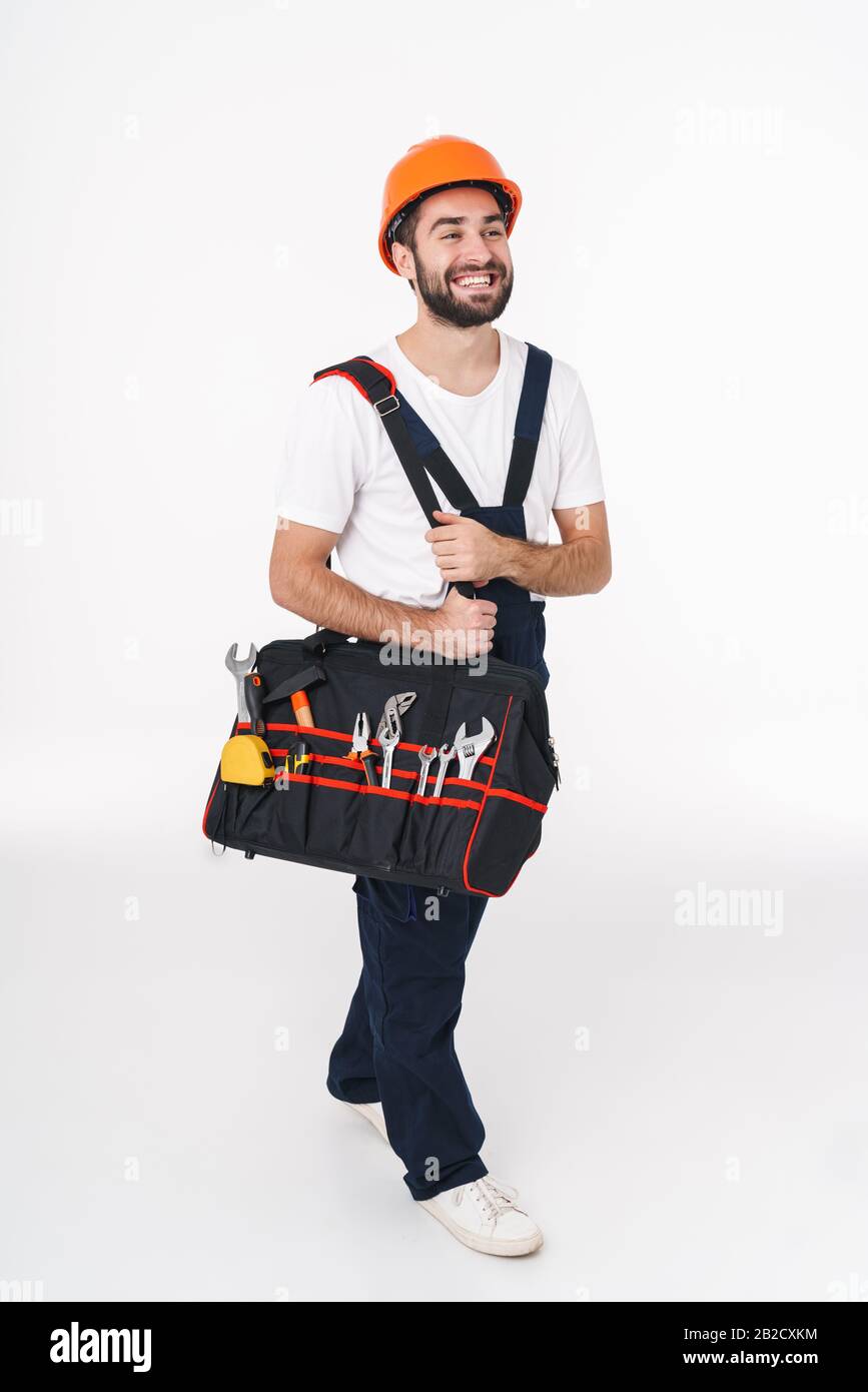 Picture of happy optimistic young man builder in helmet isolated over ...