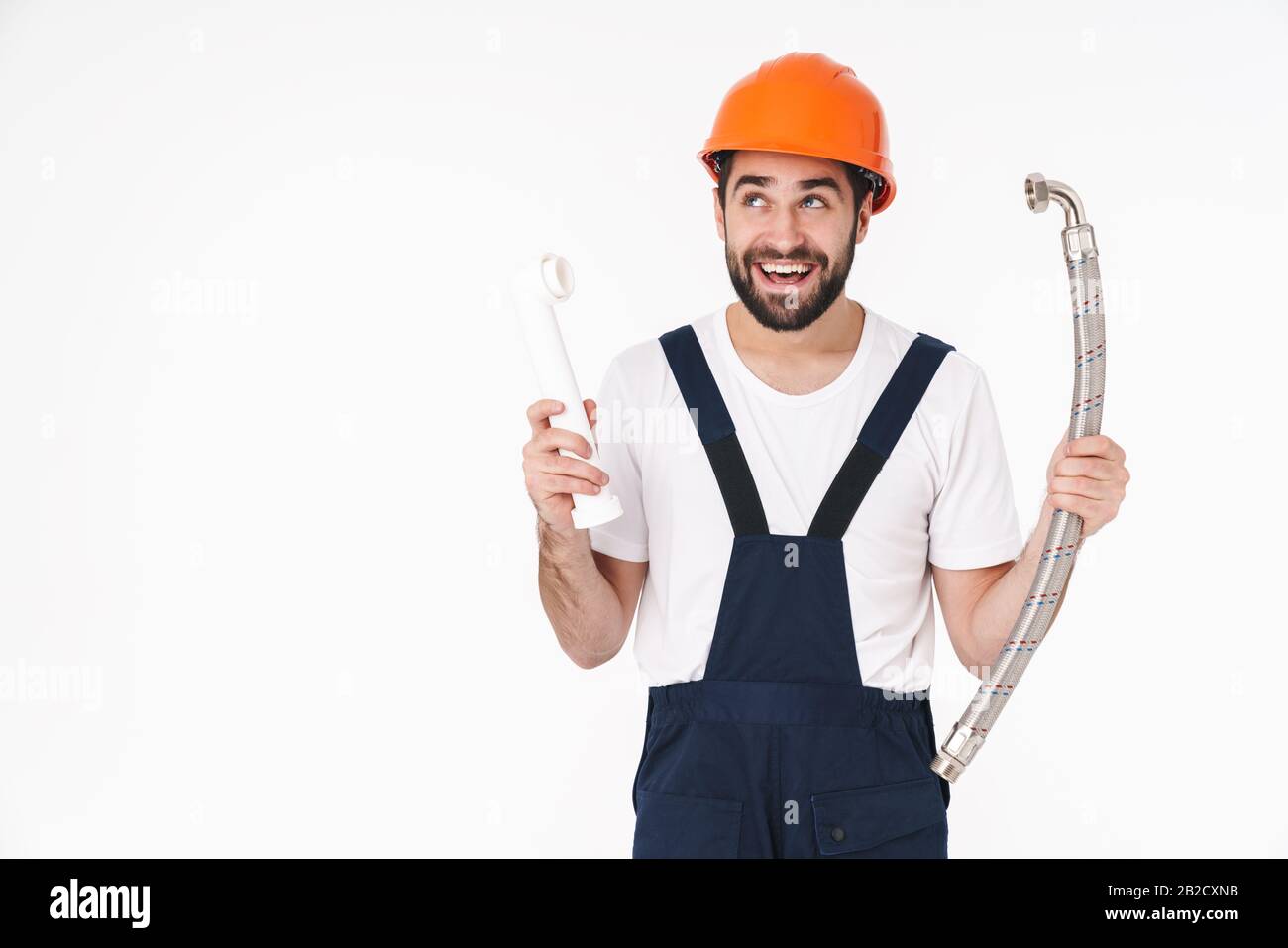 Photo of cheerful young man builder in helmet isolated over white wall ...