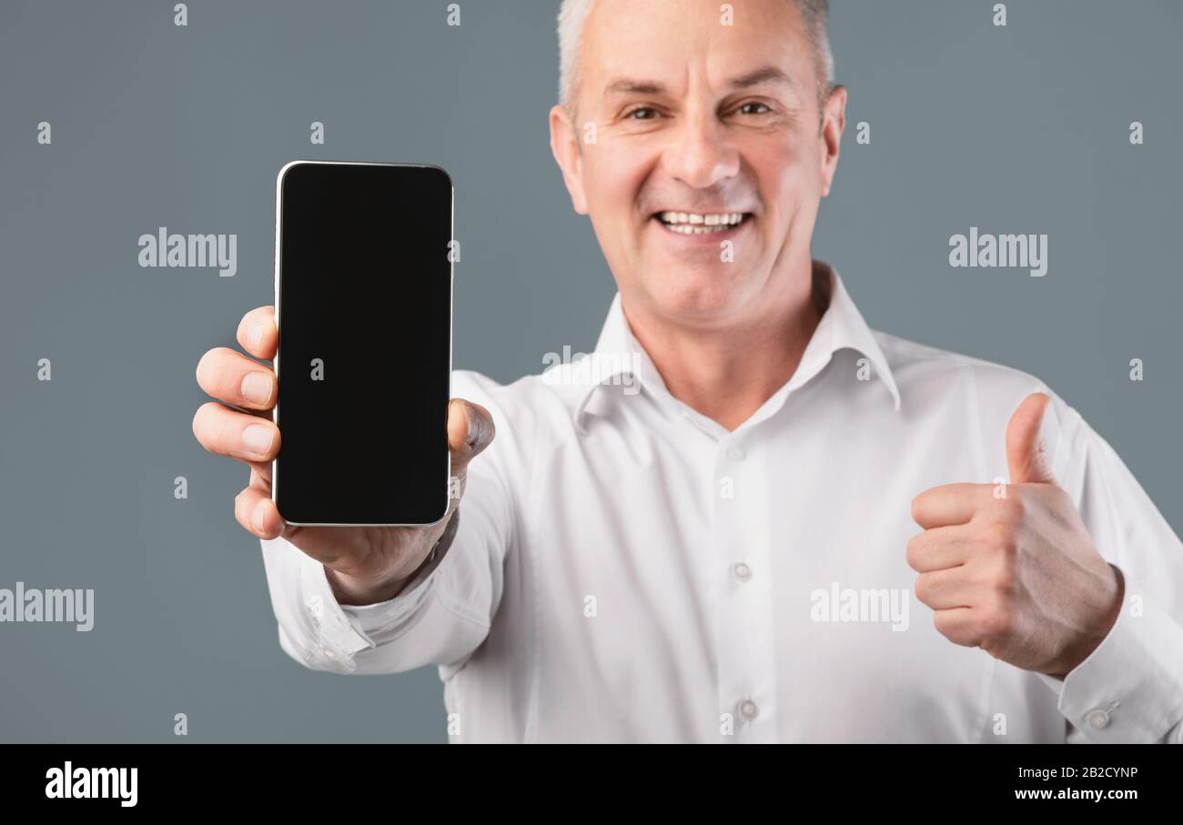 Smiling man showing mobile phone with empty screen Stock Photo - Alamy
