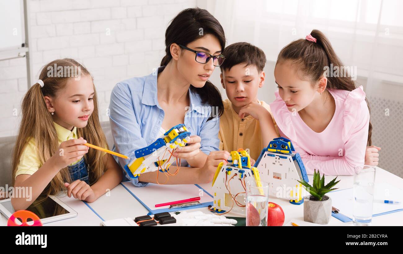 Children learning about computers and robots with their teacher Stock ...
