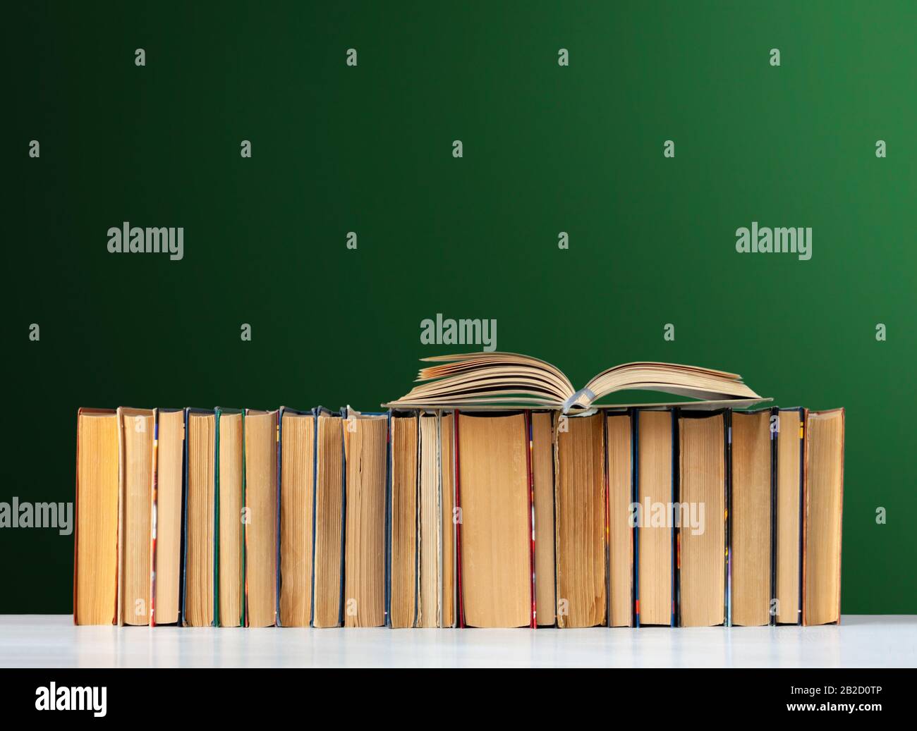 Back to school, pile of books with empty green school board background ...