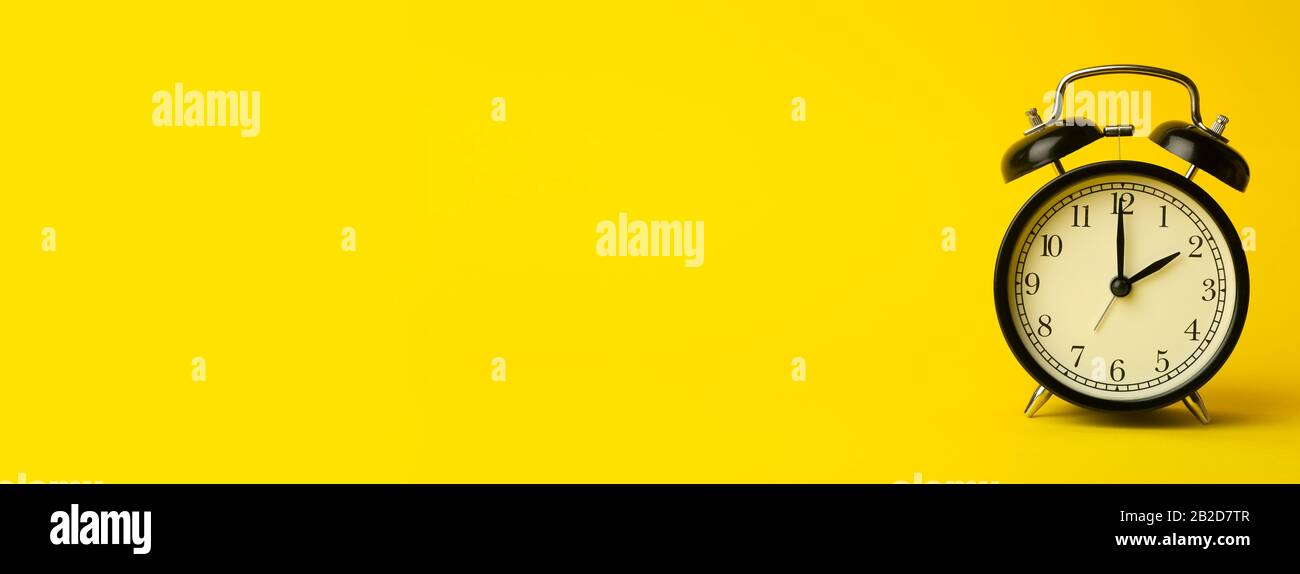 Time background concept. Vintage classic alarm clock on yellow empty ...