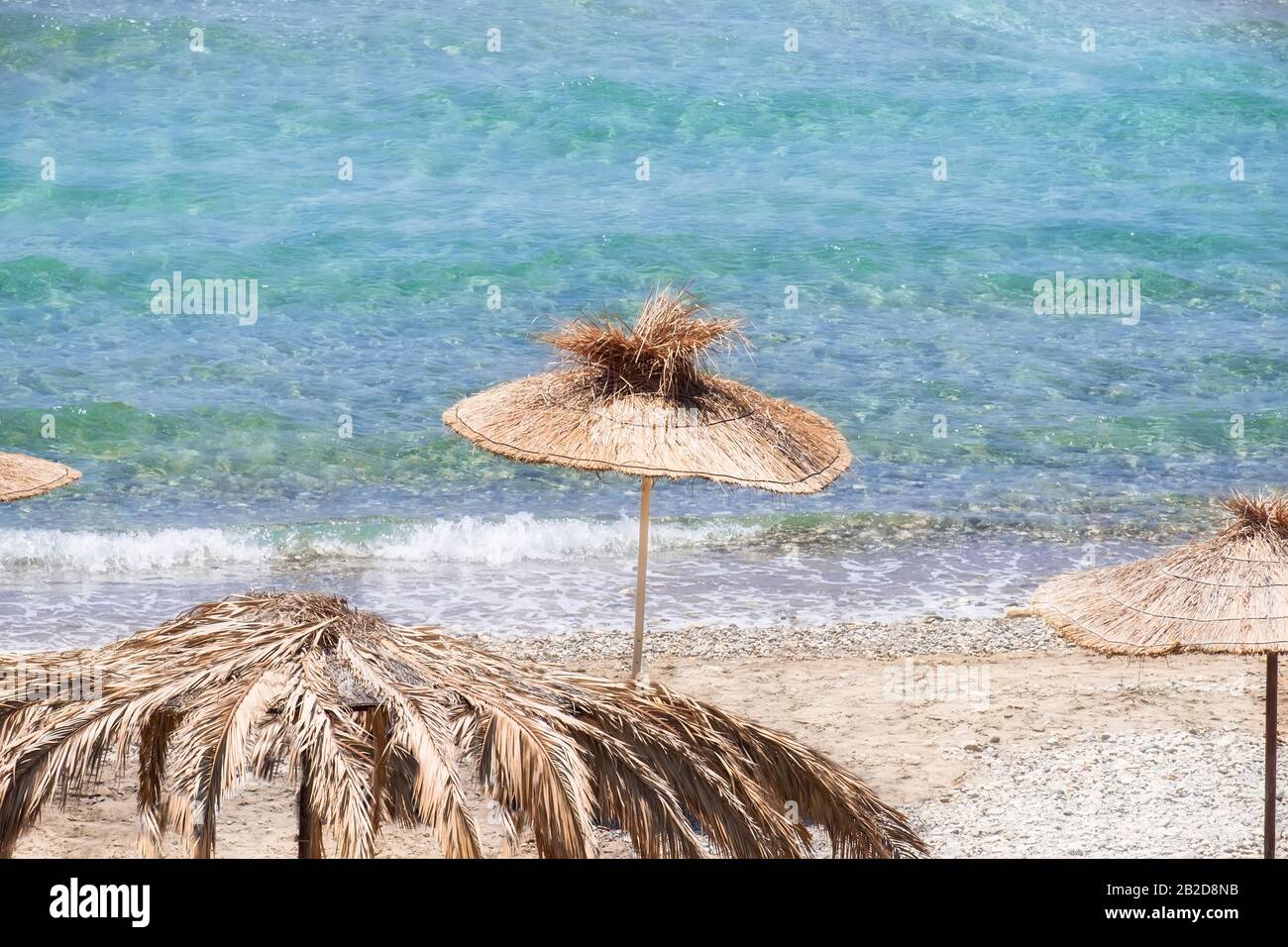 Abstract view of amazing beach landscape with straw umbrella near azure ...