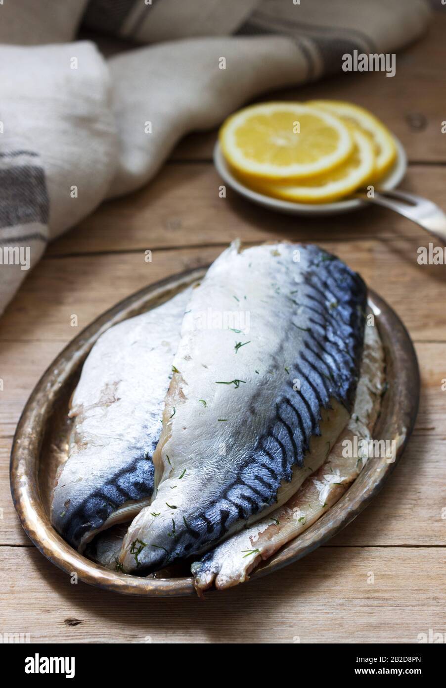 Mackerel glavrax with lemon slices on a wooden background Stock Photo ...
