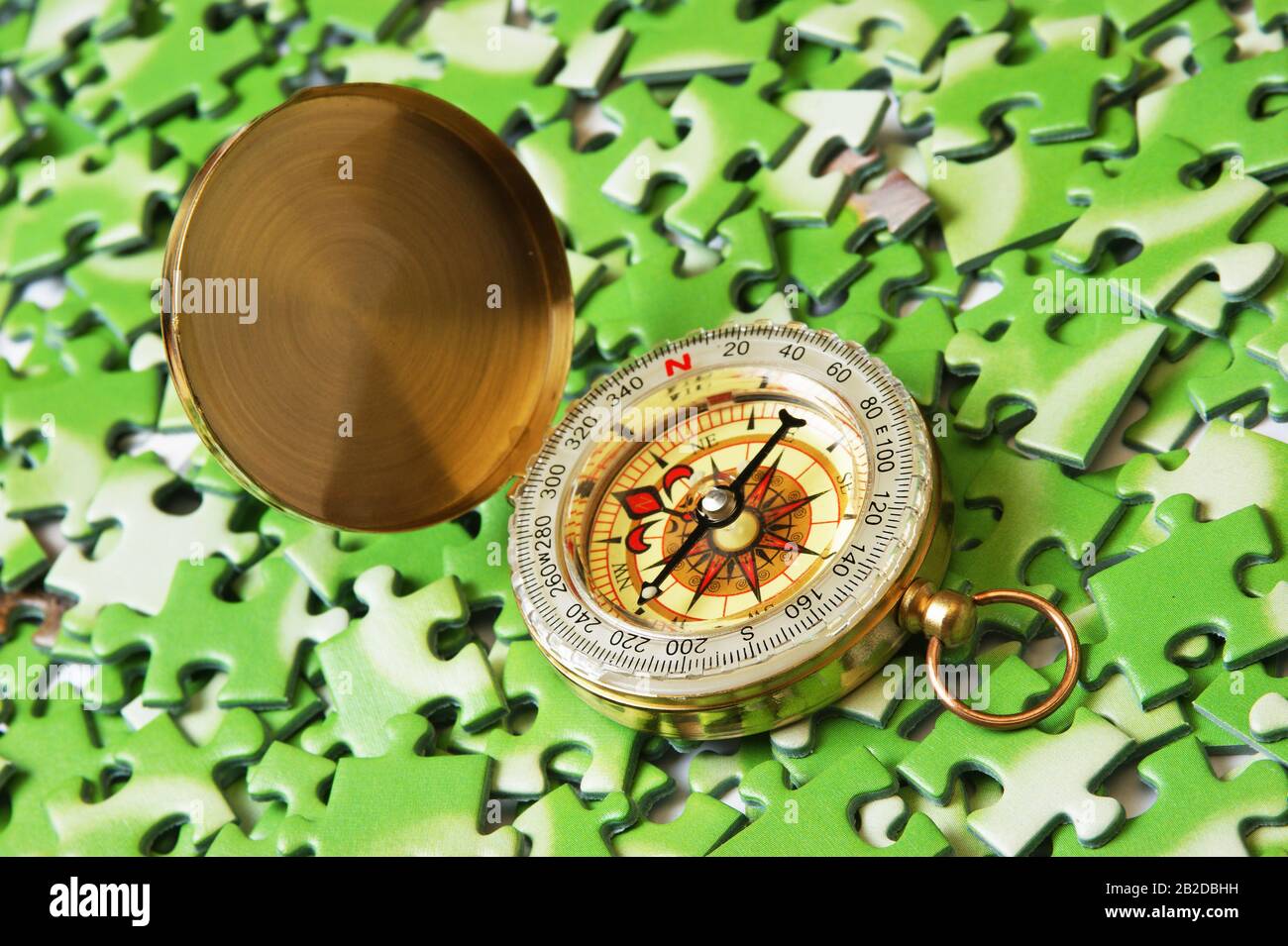 compass on pile of green puzzle Stock Photo - Alamy