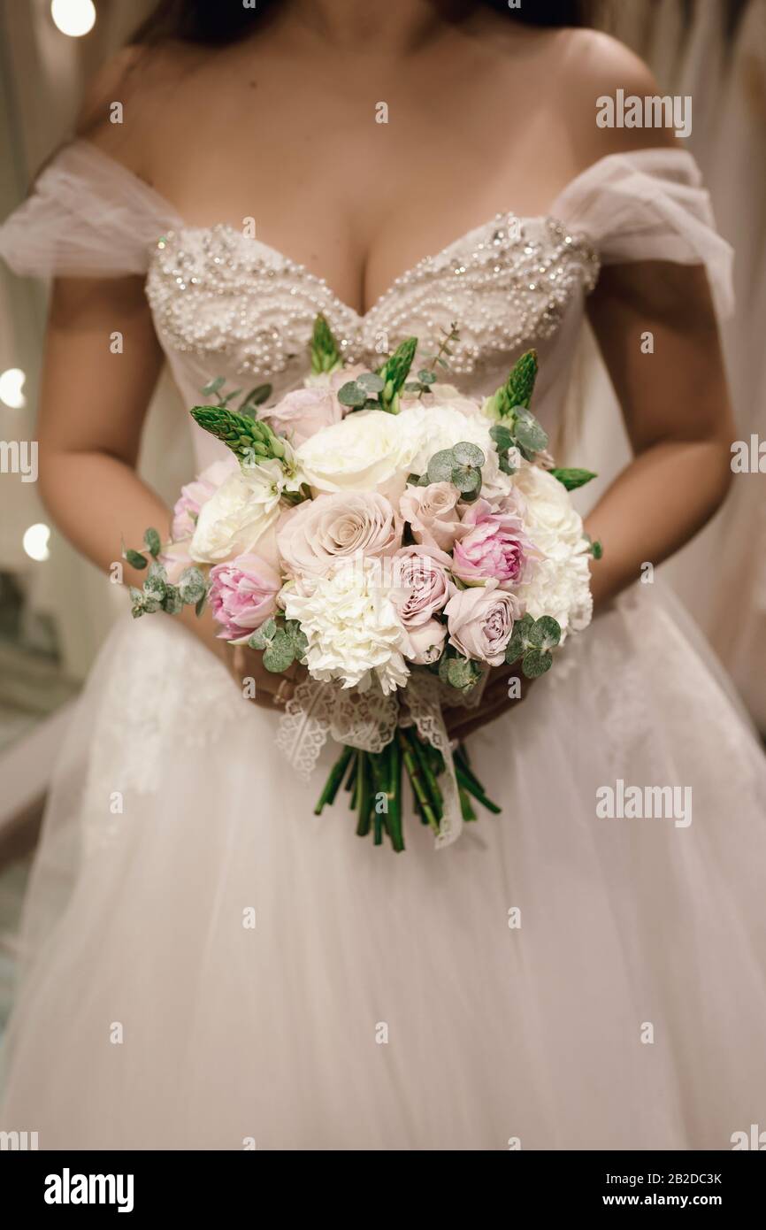 Bouquet holding by Bride she wear white wedding dress at wedding shop ...