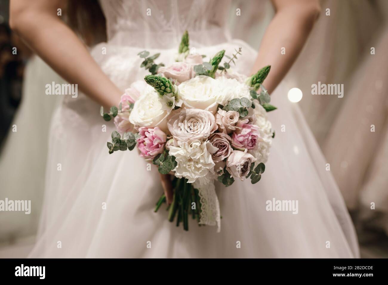 Bouquet holding by Bride she wear white wedding dress at wedding shop ...