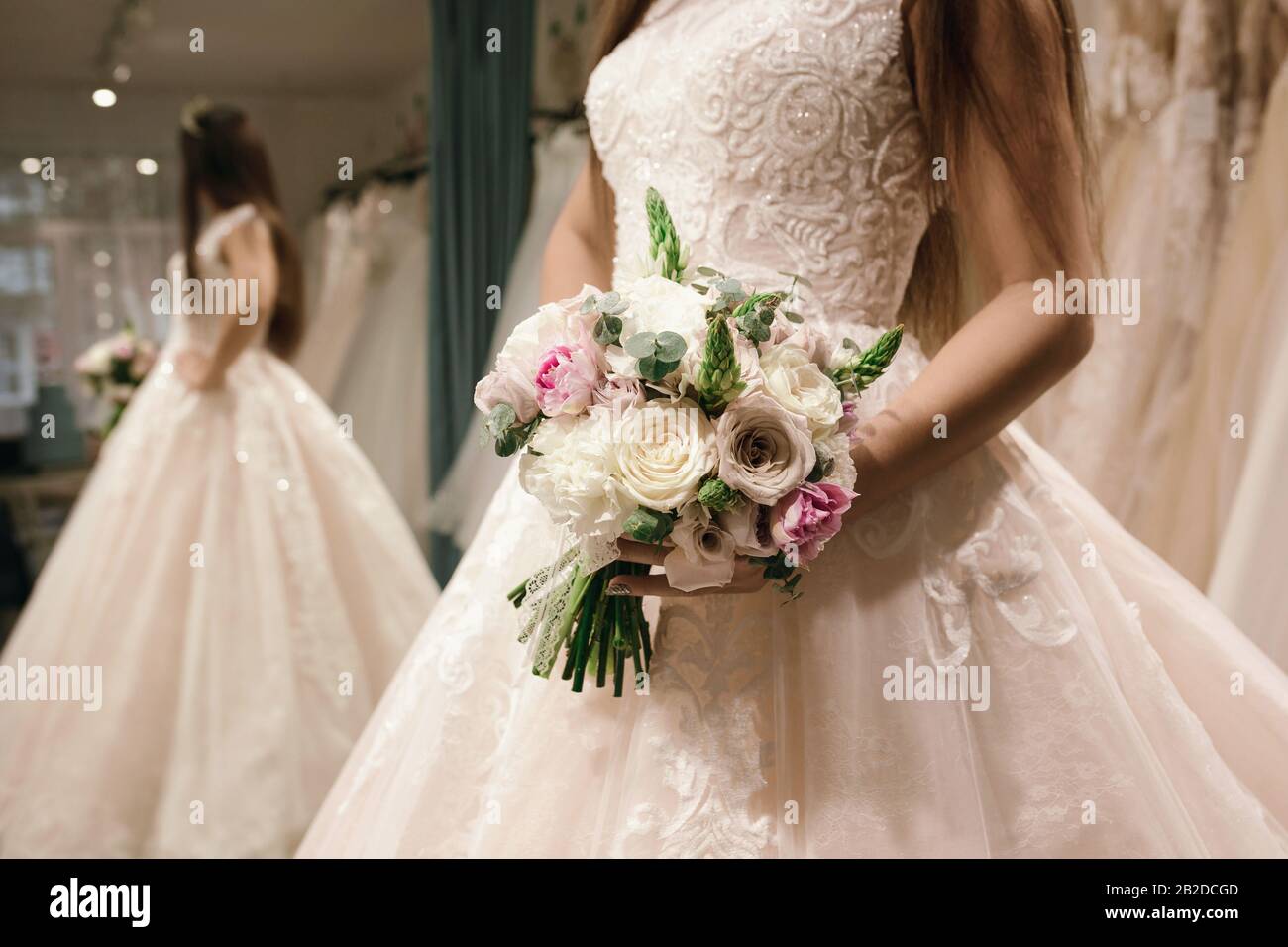 Bouquet holding by Bride she wear white wedding dress at wedding shop ...