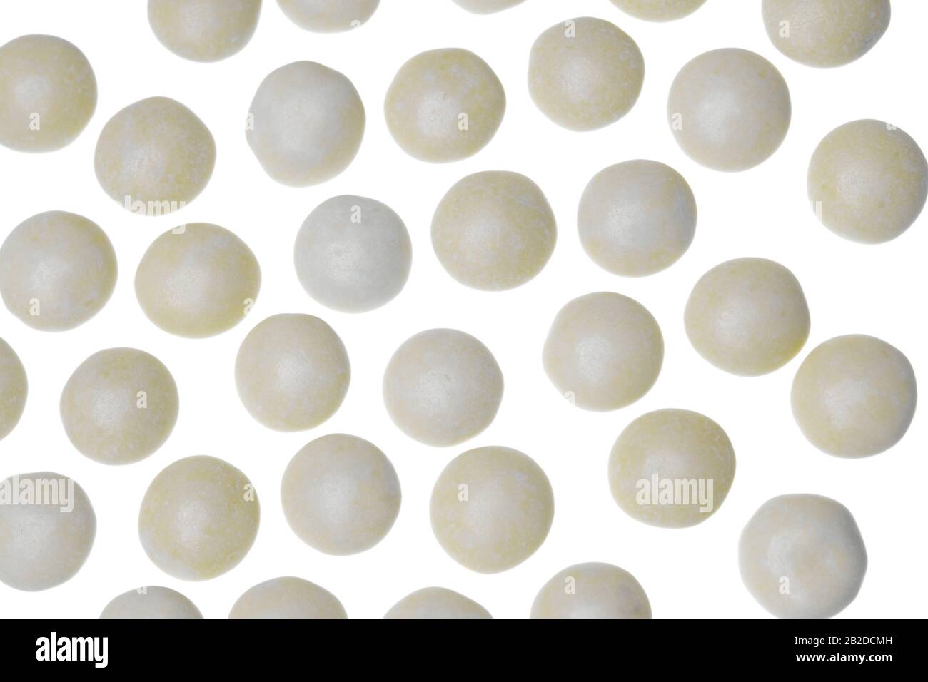 Pastel yellow sugar-coaged chocolate candy in the shape of oblate ...