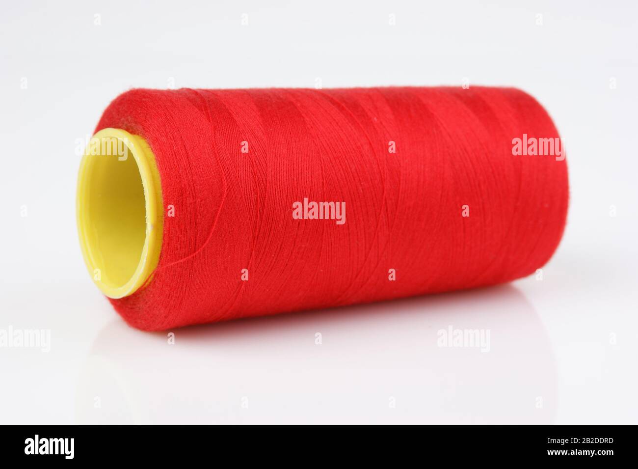 bobbin with red thread on a white background Stock Photo - Alamy