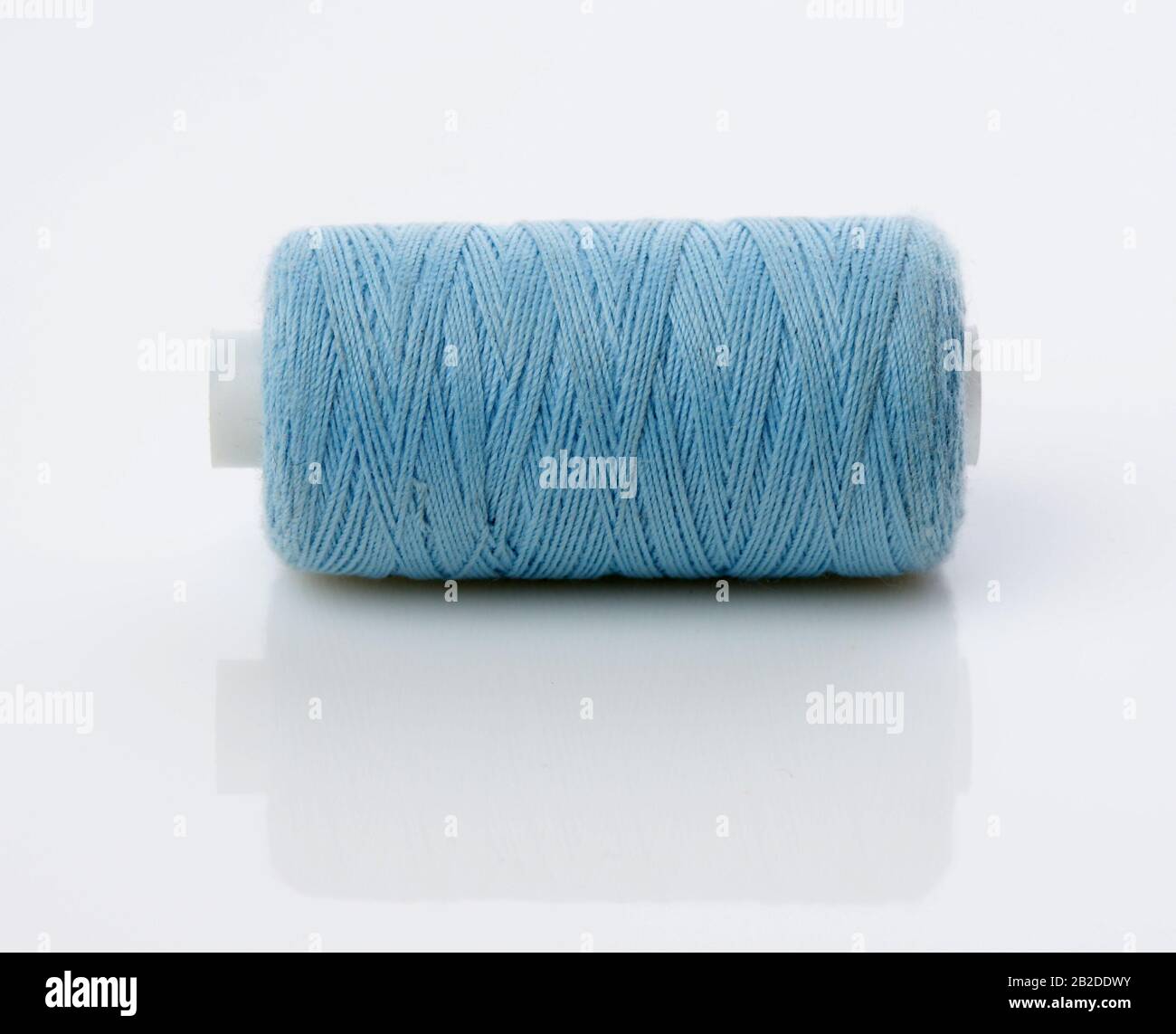 bobbin with blue thread on a white background Stock Photo - Alamy