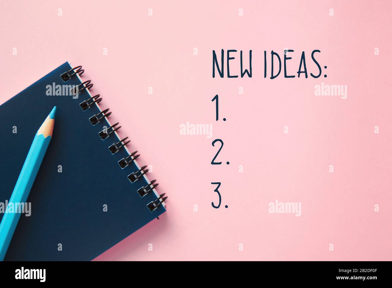 Dark blue notebook, a blue pensil on trendy pink background ...