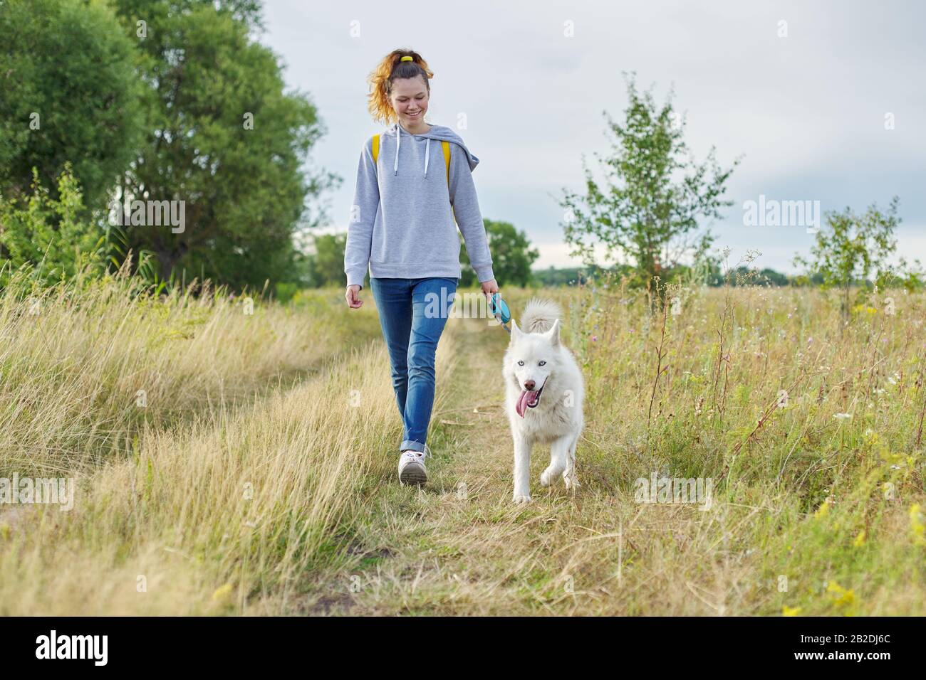 Active healthy lifestyle, teen girl walking with white husky dog Stock ...