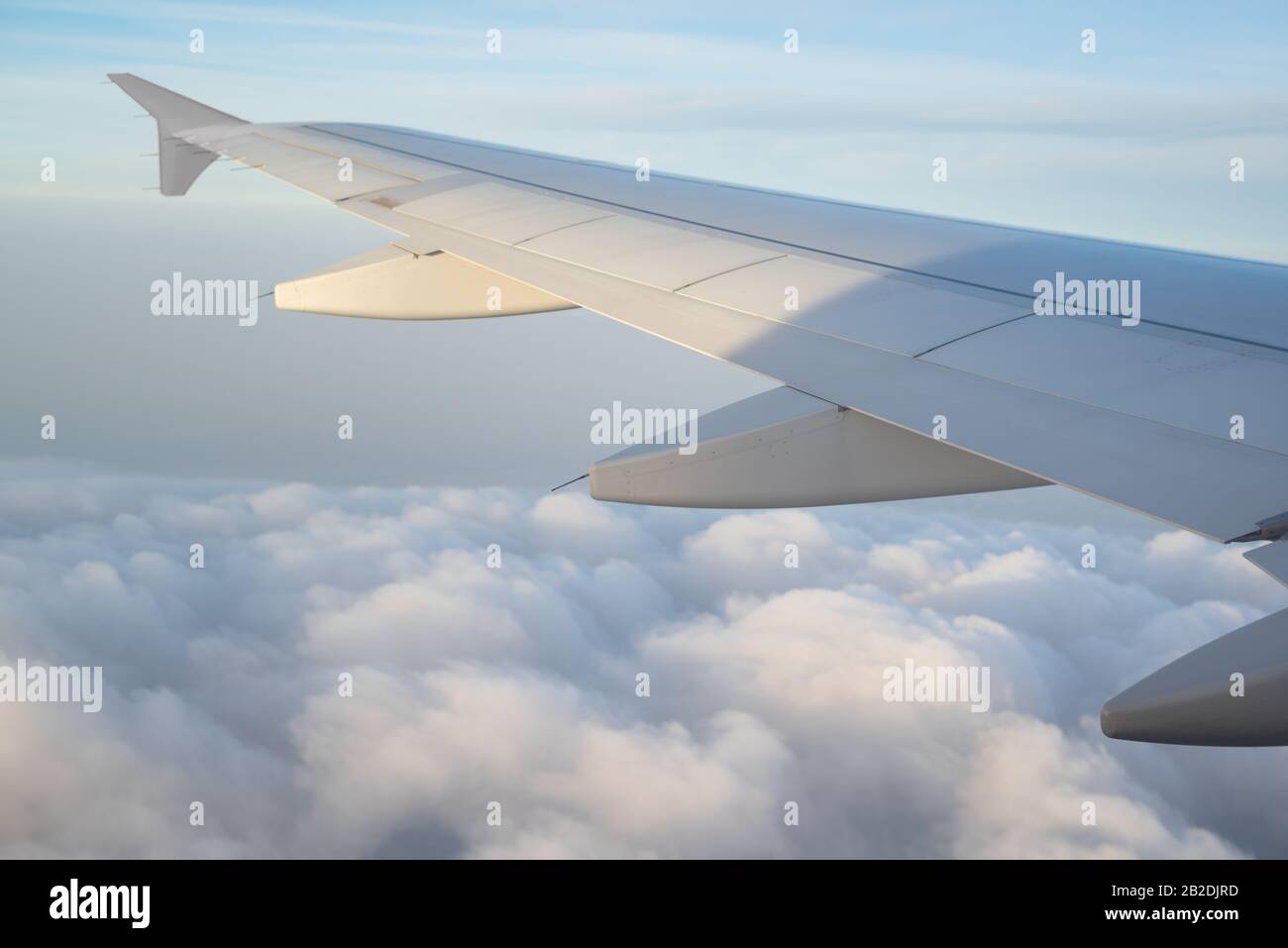 Airplane wing in the sky flying above the clouds, view from the plane ...