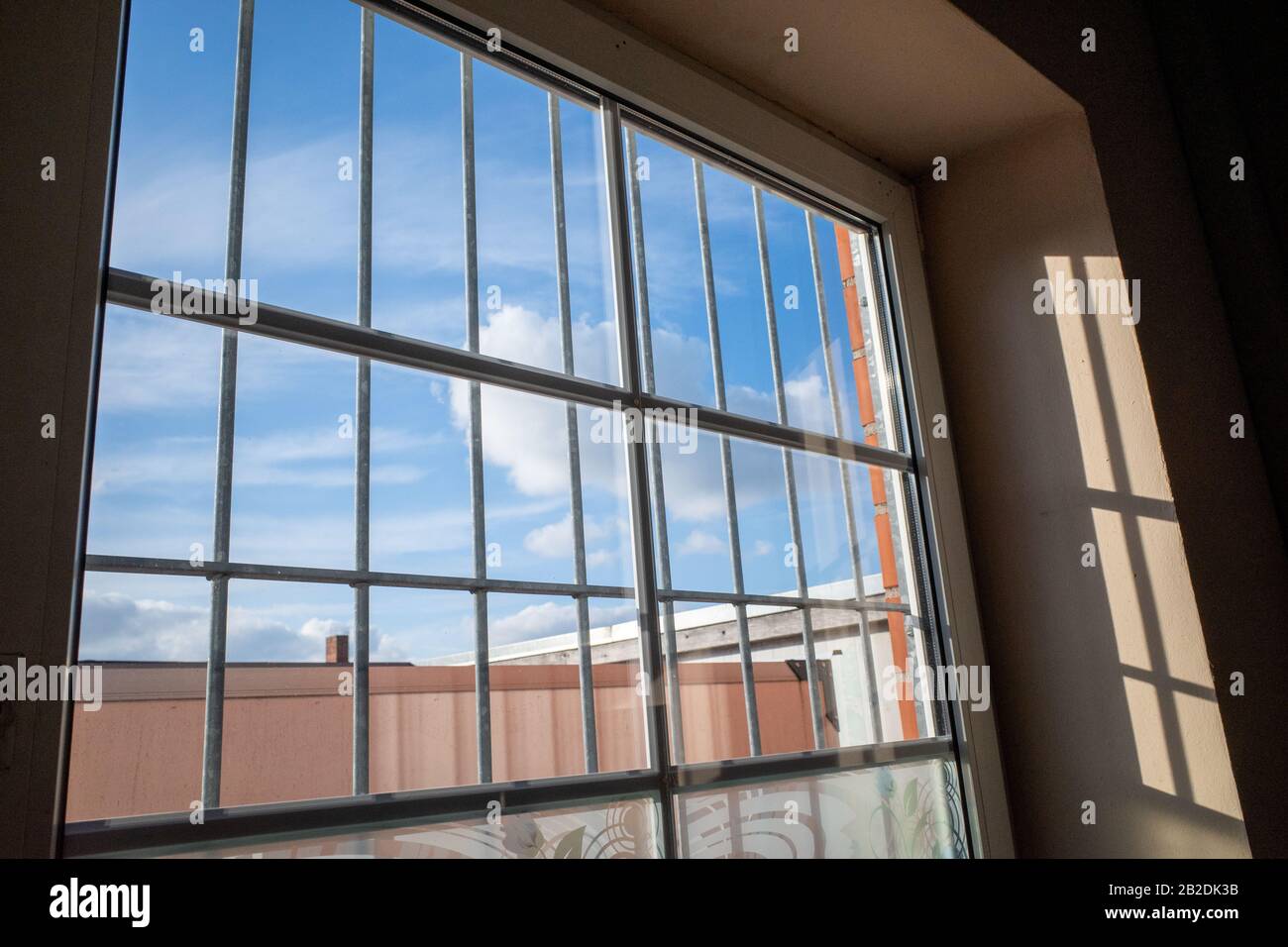 the view from a barred window to the blue sky with white clouds Stock ...