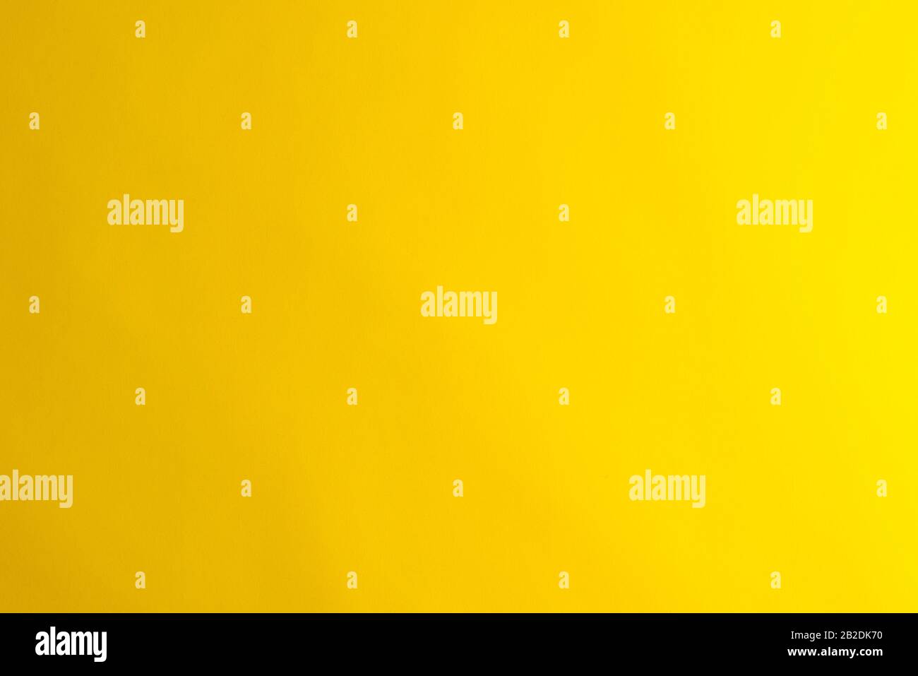 Yellow background made of real colored paper, illuminated by a soft ...