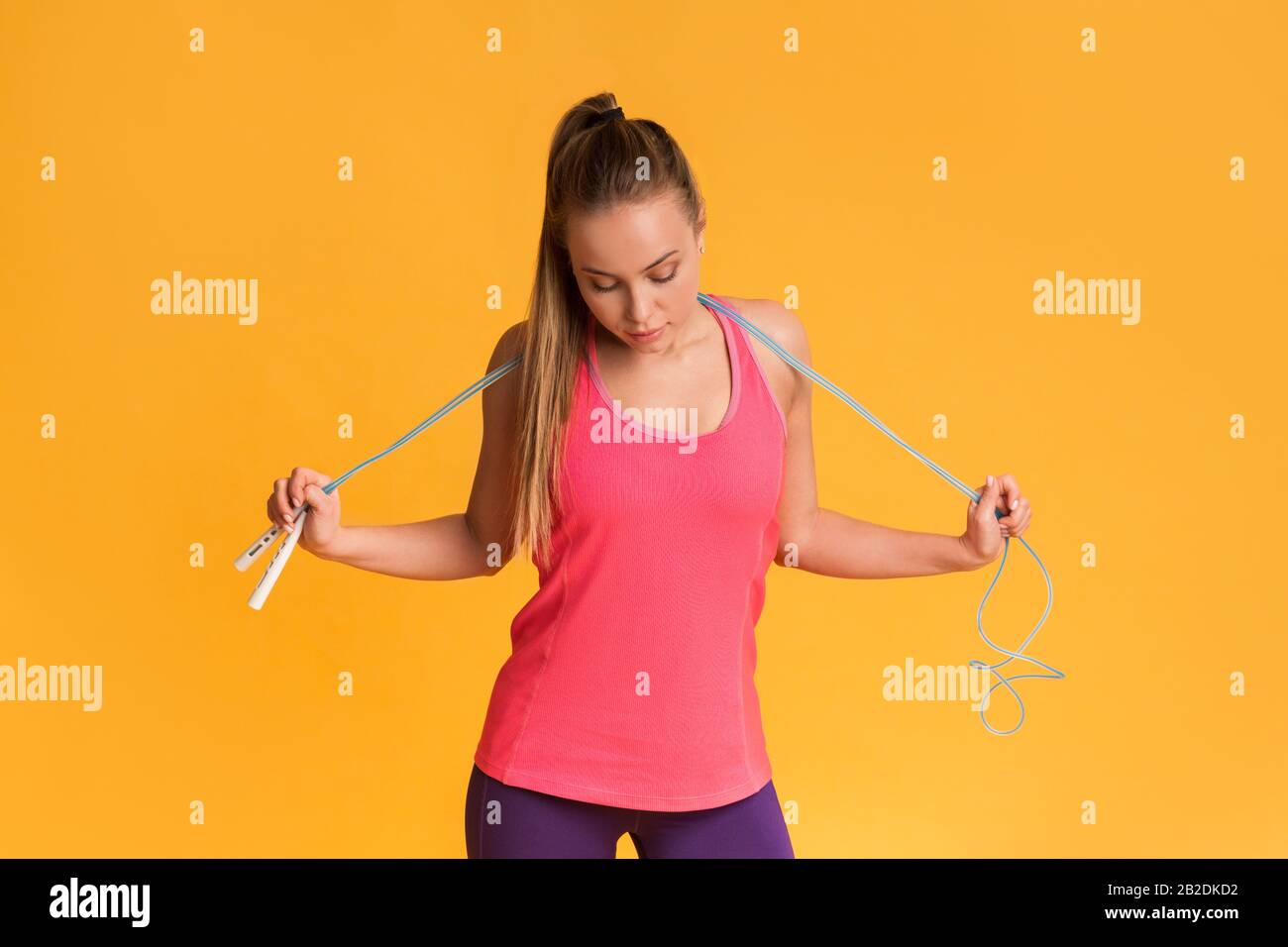 Girl posing with jump rope and looking at her fit body Stock Photo - Alamy