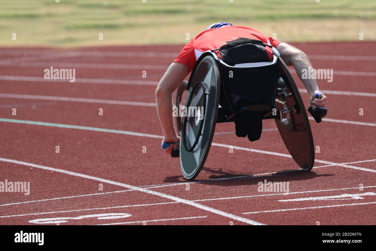 muscular athlete runs on the wheelchair in the running track Stock ...