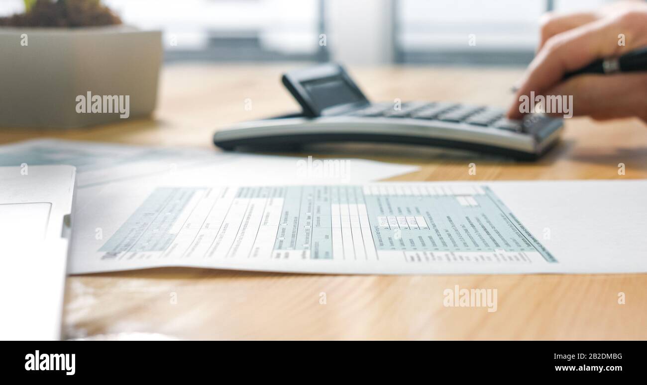 Closeup of US tax form 1040 and hand calculating and filling report ...