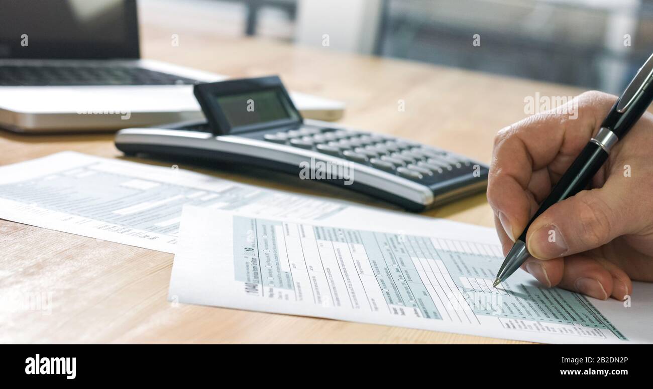 Closeup of US tax form 1040 and businessman hand calculating and ...