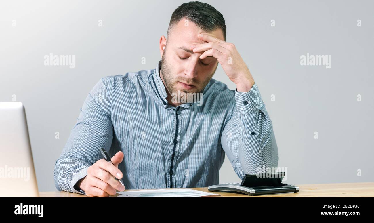 Unhappy accountant businessman stressfuly filling tax form with ...