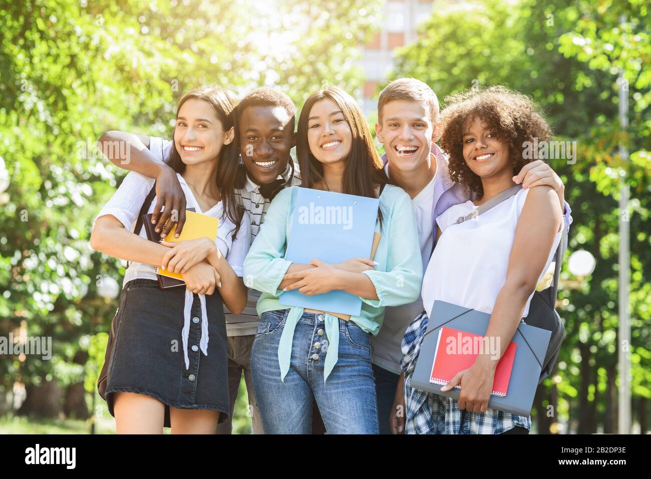 Portrait of happy multicultural students posing at camera outdoors ...