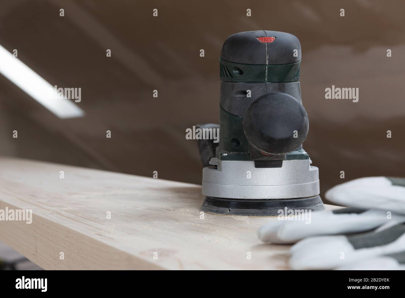 Carpentry. Wood sanding. Orbital sander for woodworking. In a natural ...