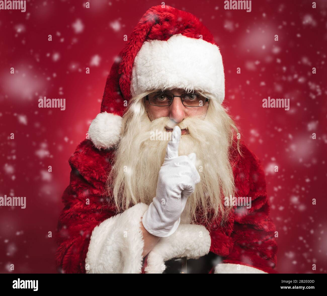 santa claus making the quiet gesture with finger over his mouth on red ...