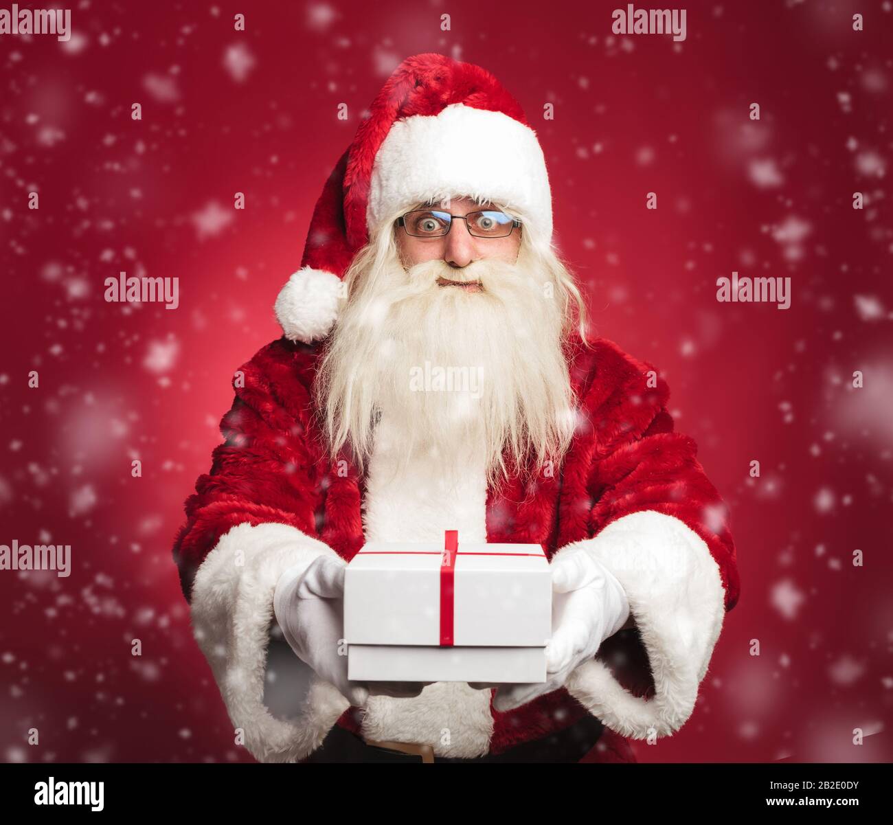 happy santa claus offering a present to all the good kids on red ...