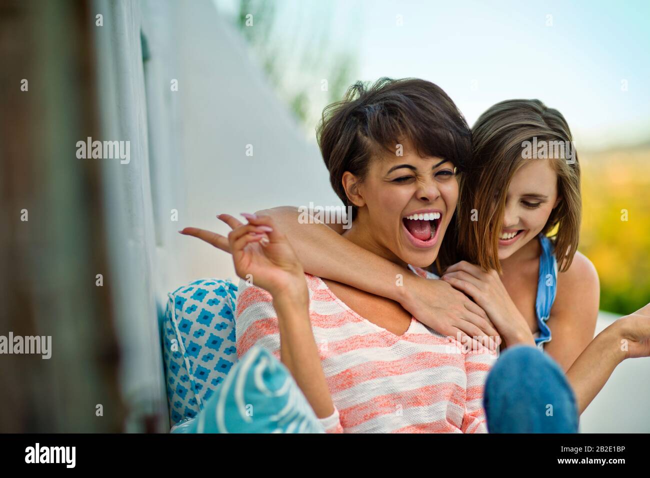 Two friends smiling and hugging Stock Photo - Alamy