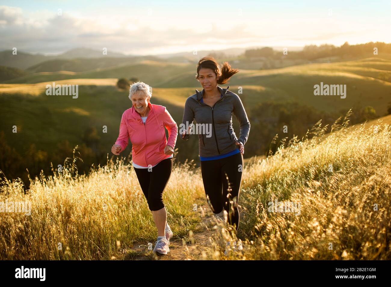 Two women running together on an outdoor trail Stock Photo - Alamy