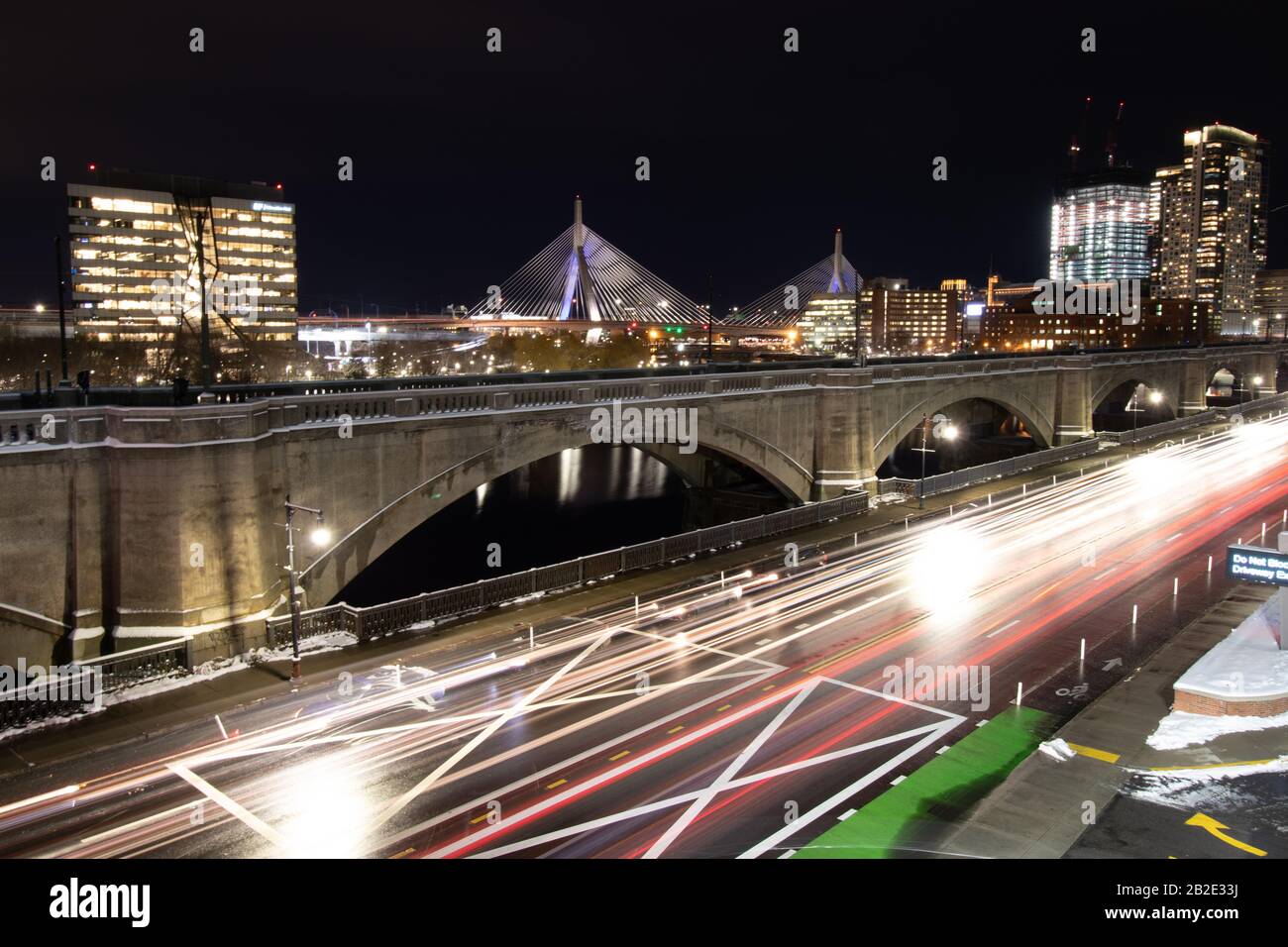 cityscape of boston at night with bridges and light trails from cars ...