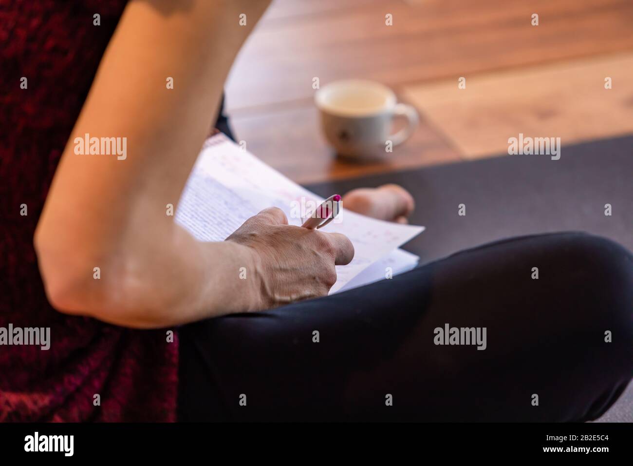 The unrecognizable female studying hard and making notes on a pad. The ...