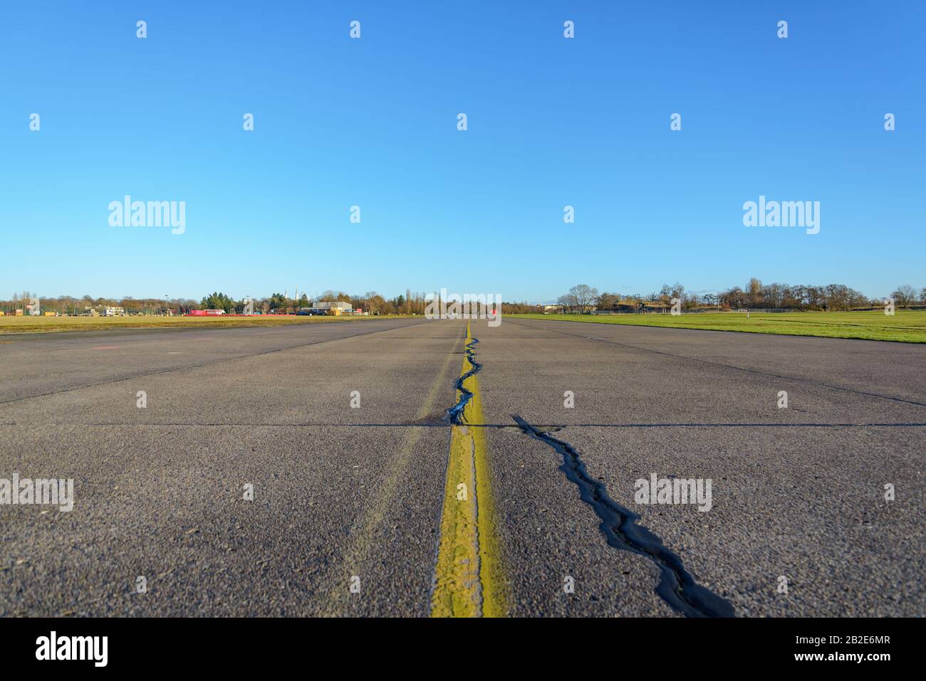 Low angle diminish perspective view of cracking asphalt road, airport ...