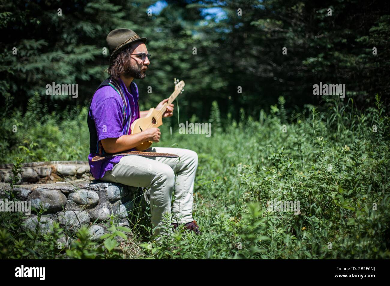 Side view of a man playing a musical instrument - merlin. A young ...