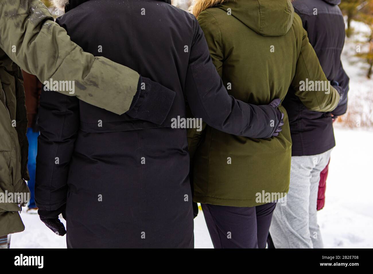 People hug each other and stand around. The warmly dressed ...