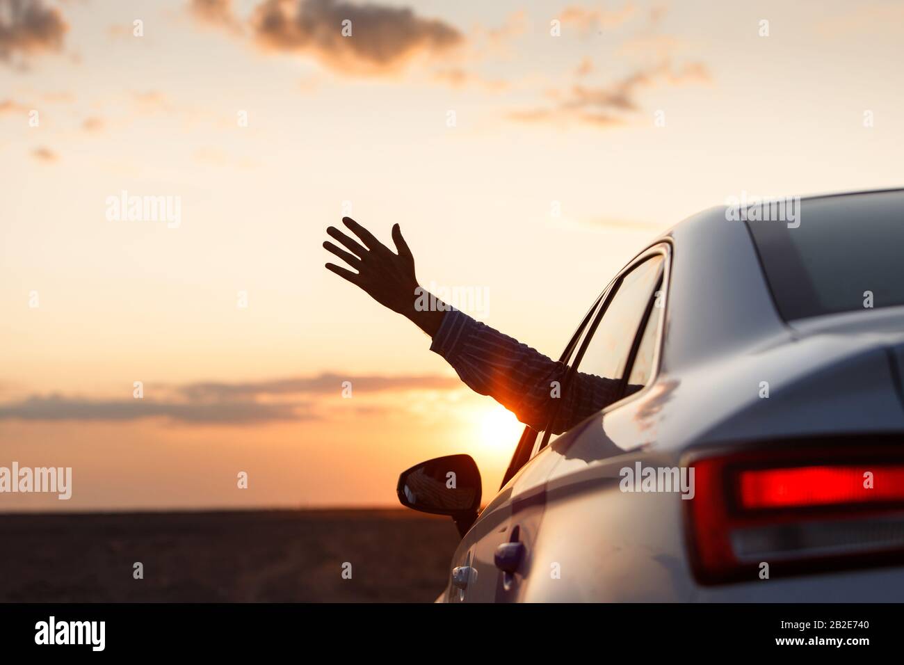 Man inside car showing his hand outdoor/leaning out of car window at ...