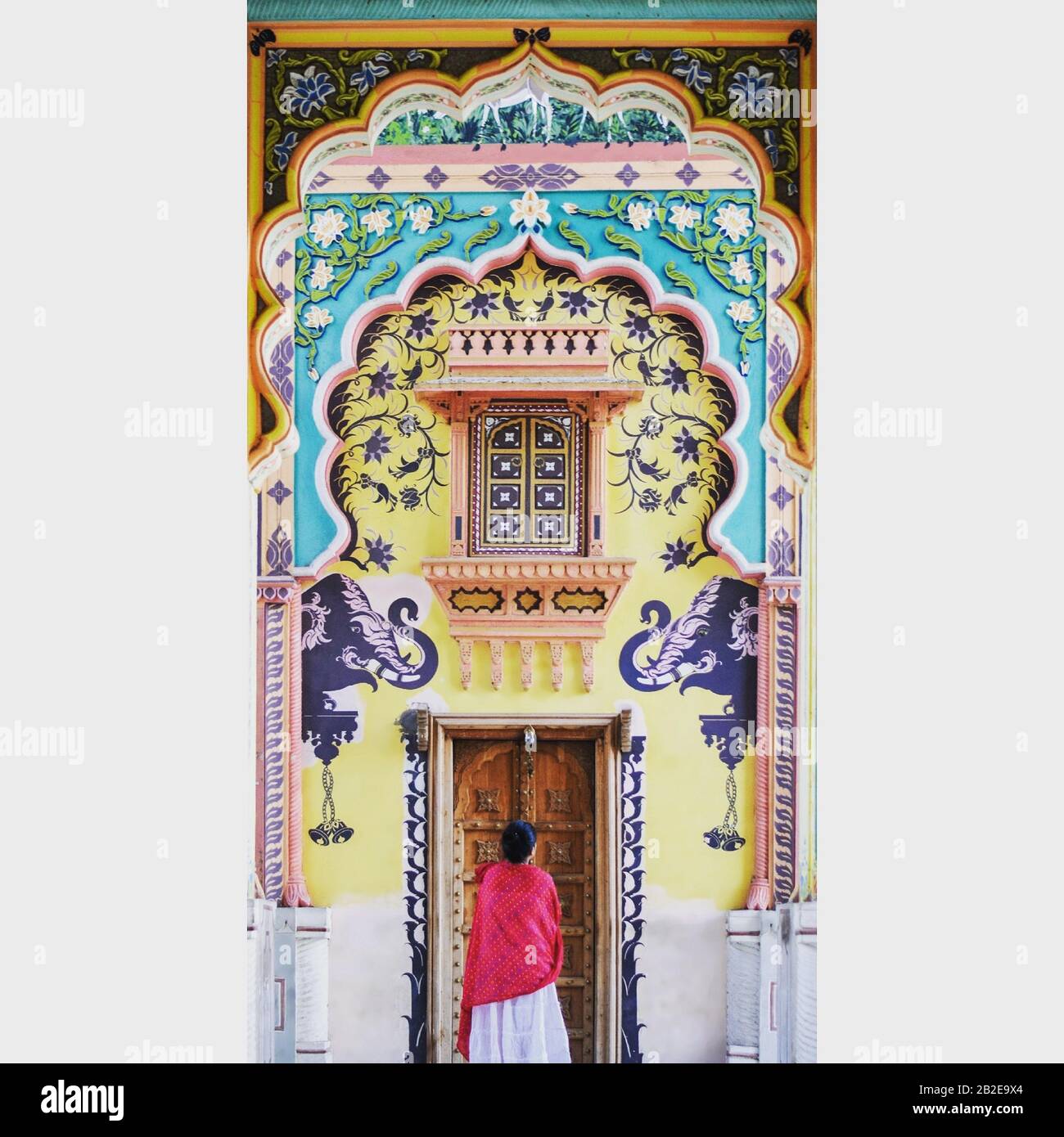 A lady admiring the painting on the walls of Patrika Gate, Jaipur Stock ...