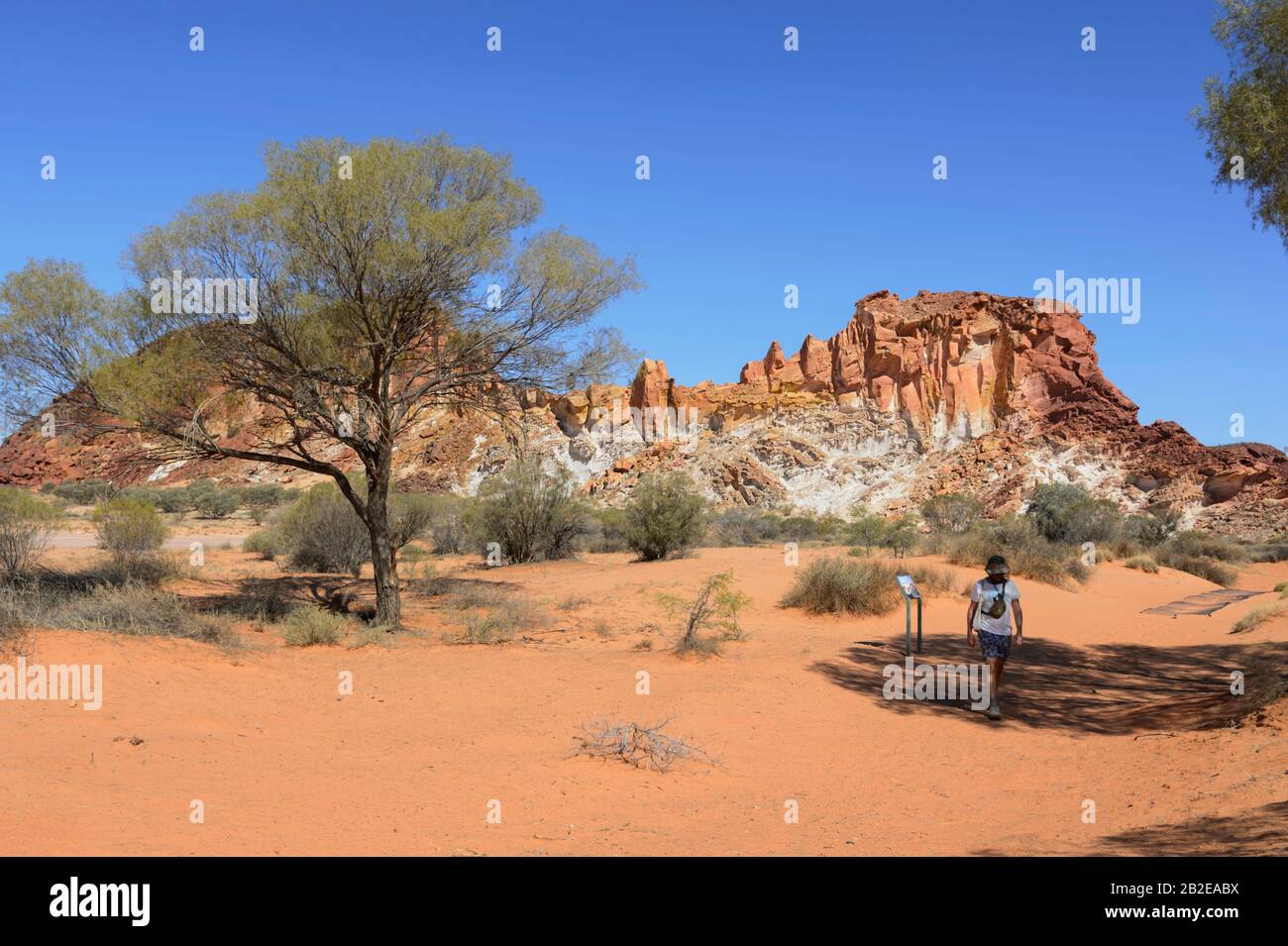 Tourist on a walking trail at Rainbow Valley, an iconic colourful ...