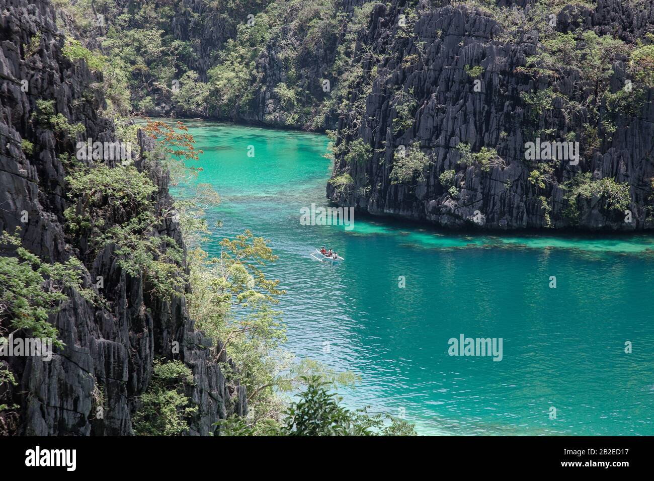Boat navigating through the cliffs of Palawan, Philippines Stock Photo ...