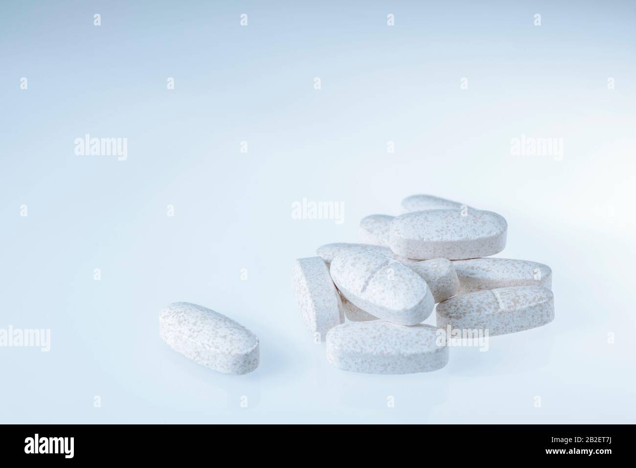 Close-up of a small cluster of elongated speckled tablets with single ...