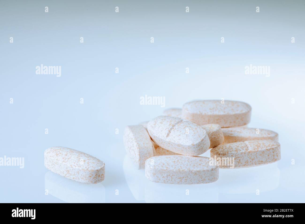 Close-up of a small cluster of elongated speckled tablets with single ...