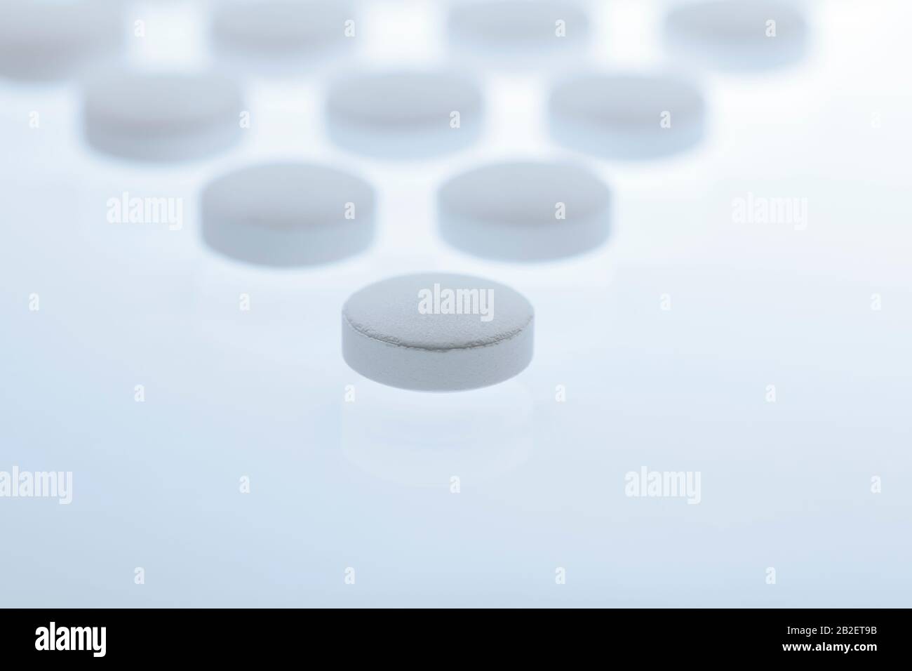 Close-up of triangular arranged round tablets with the tip pointing to ...