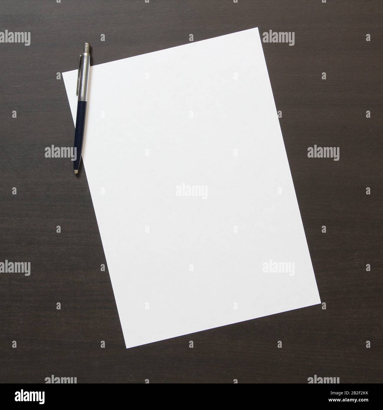 Template of white paper with pen on dark wenge color wooden background ...