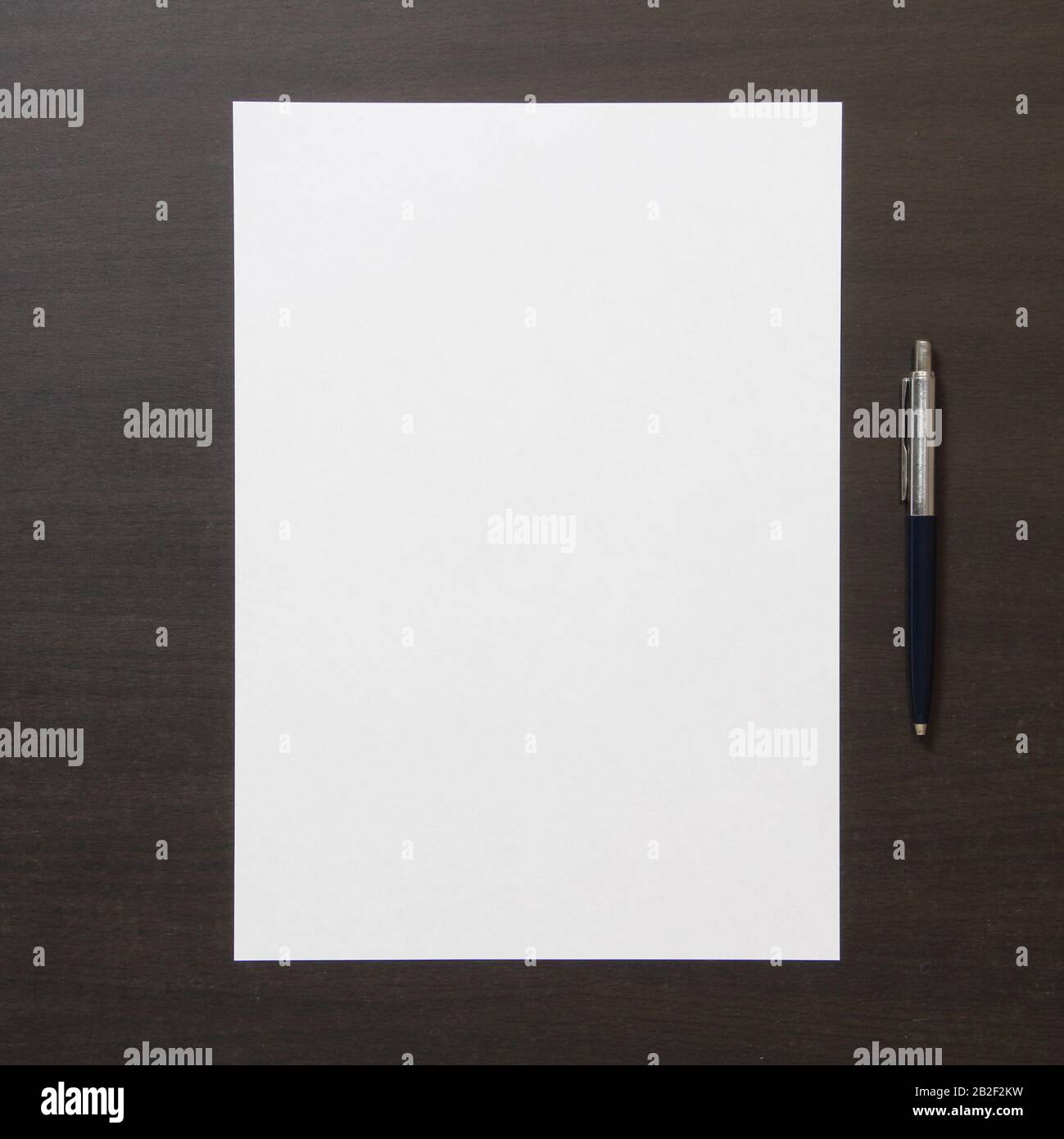 Template of white paper with pen on dark wenge color wooden background ...