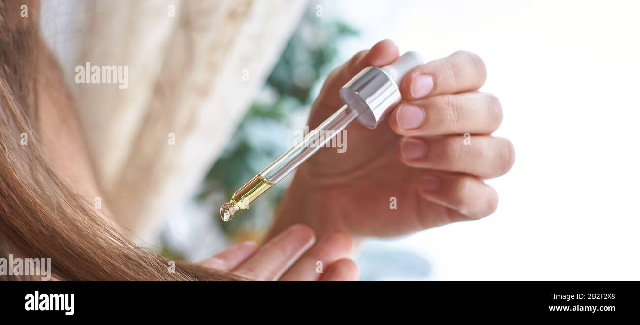 Hair care routine. Oil for head. Girl holding dropper Stock Photo - Alamy
